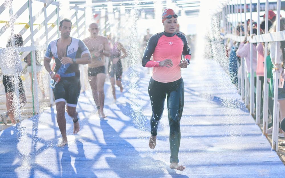 woman-finishing-triathlon-in-full-skin-swim-race-suit - Hunting Waterfalls