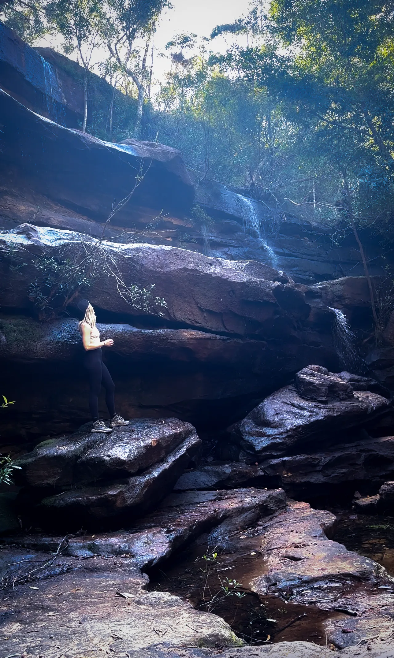 woman-standing-on-rock-at-base-of-uloola-falls - Hunting Waterfalls